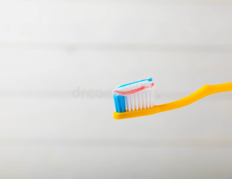 Toothpaste on a Yellow Toothbrush. Composition on a White Background ...