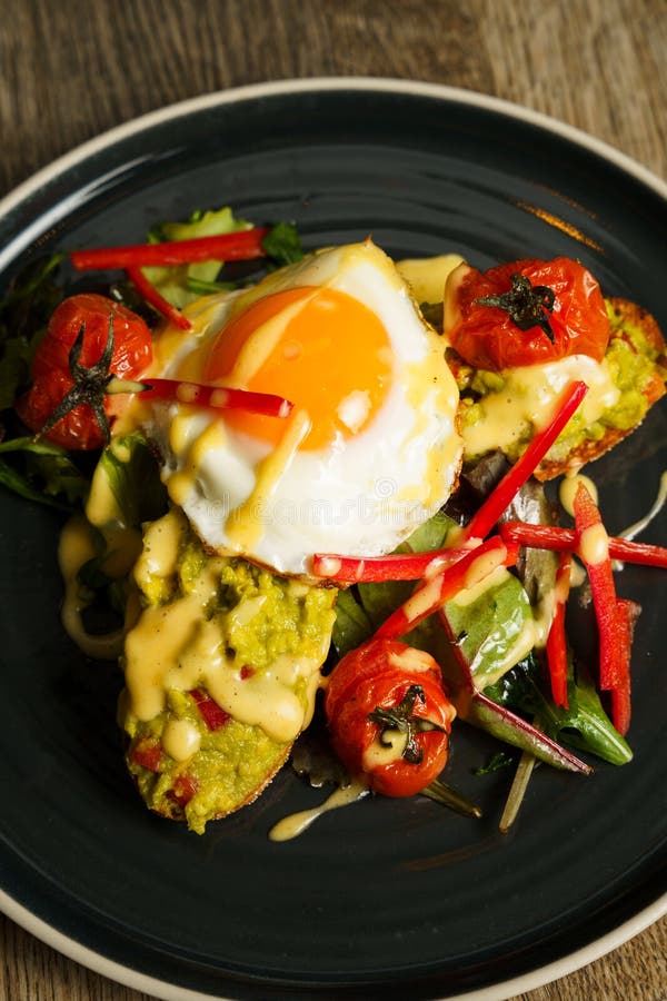 Top Down of Avocado Toast with Fried Eggs and Vegetables Stock Photo ...