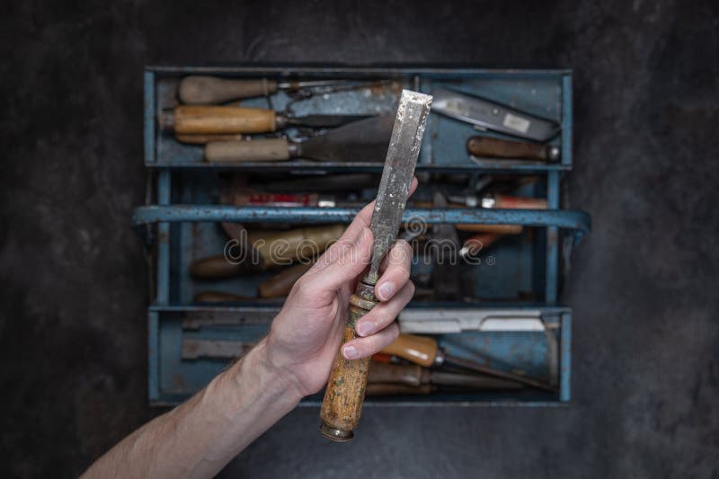 Open Metal Toolbox from Above with Hand Holding Wooden-handled Chisel ...