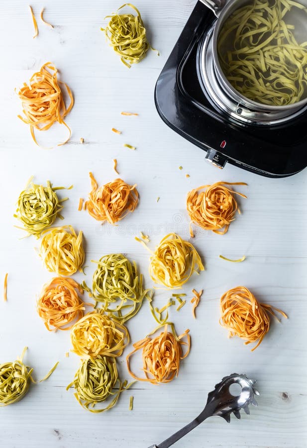 Top Down View of Fettuccine Nests and a Pot of the Same Cooking. Stock ...