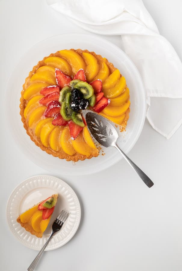 Top Down View of German Fruit Flan on a White Cake Stand with One Slice ...