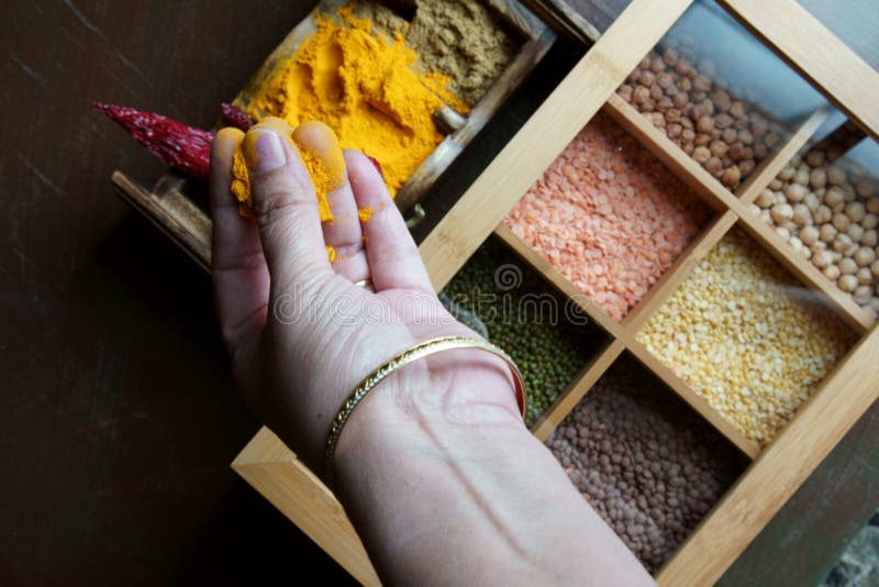 A Hand with a Pinch of Turmeric from a Spices Box. Stock Photo - Image ...