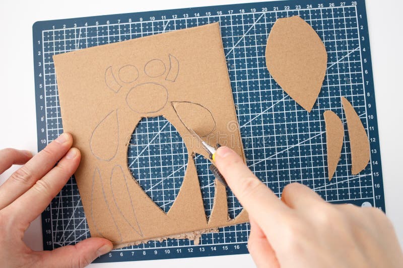 Top Down View of Hands Cutting Cardboard with Utility Knife on Cutting ...