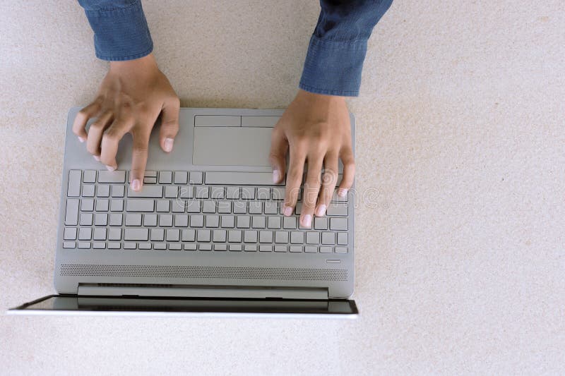 A Top-down View of Hands Typing on a Laptop Placed on a Neutral Stock ...