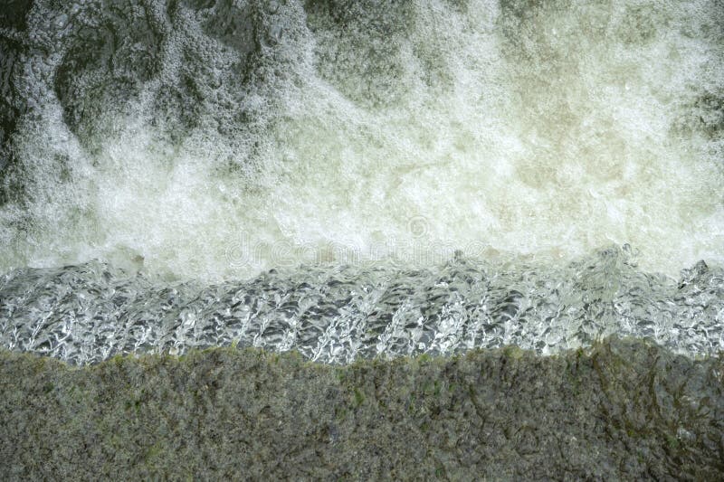 Top-down View of Water Powerfully Cascading Over a Textured Stone Edge ...