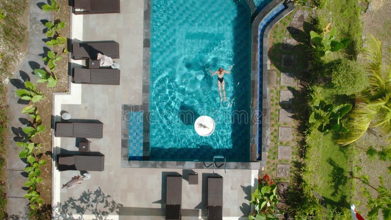 Top Down View of a Woman Swimming in a Private Pool Surrounded by ...