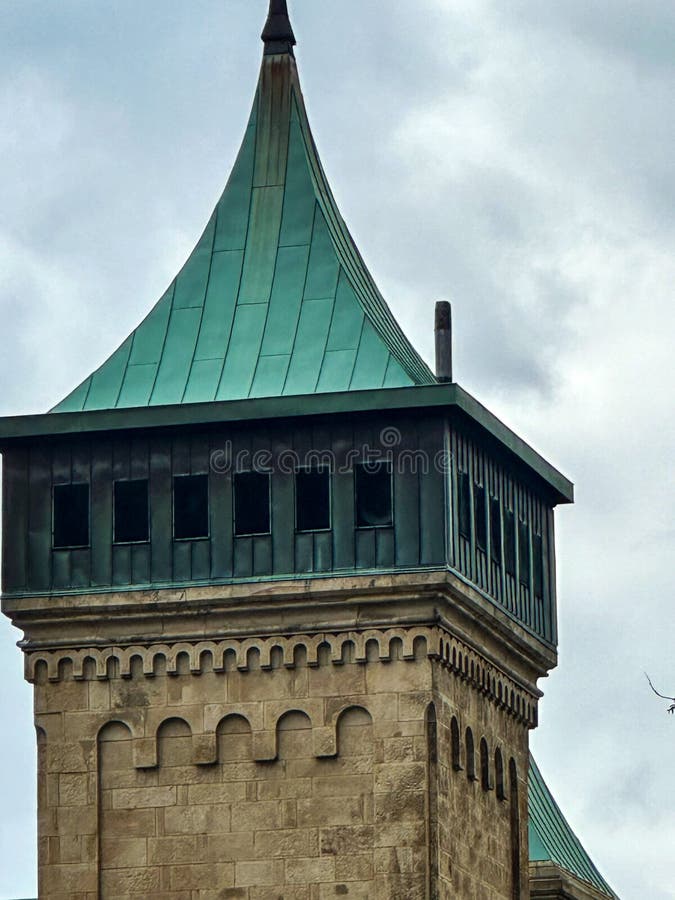 Top of Ornamental Building with Green and Tan Colored Bricks and Stone ...