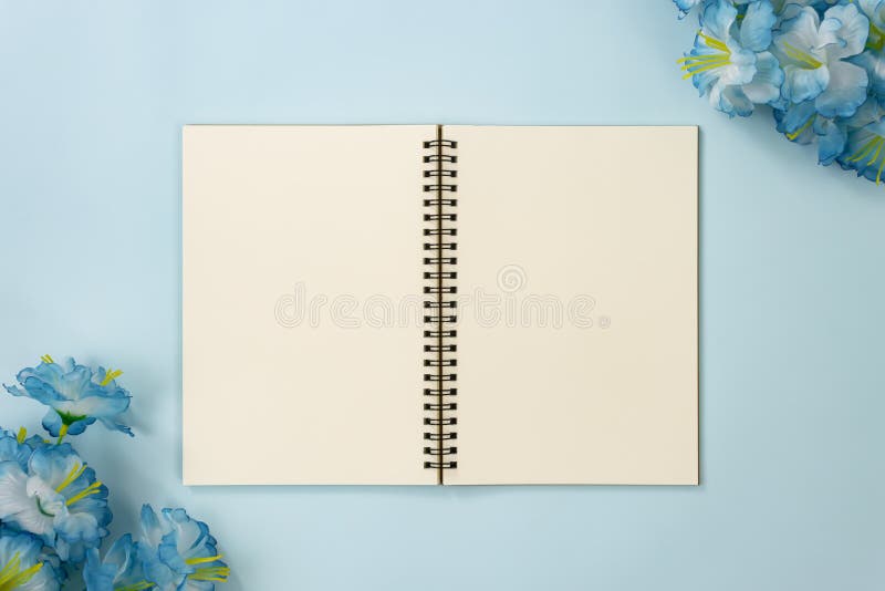 Top Table Spiral Notebook and Blue Flowers at Bottom Left and Top Right ...