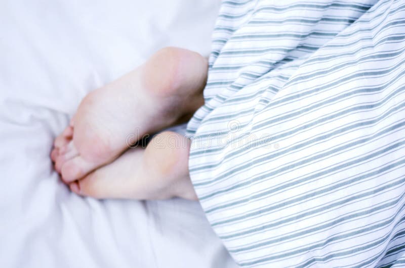 Top View Angle of a Pair of Feet Coming Out from Under the Blanket ...