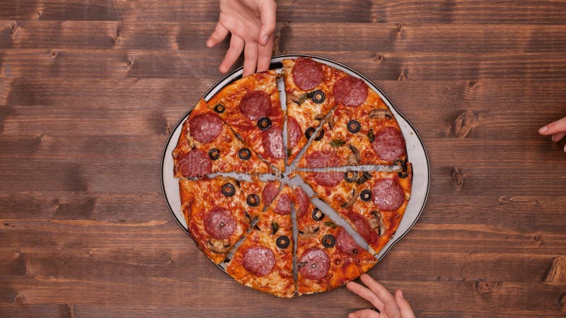 Top View of the Pizza on the Table. Hands Disassemble Slices of Pizza ...