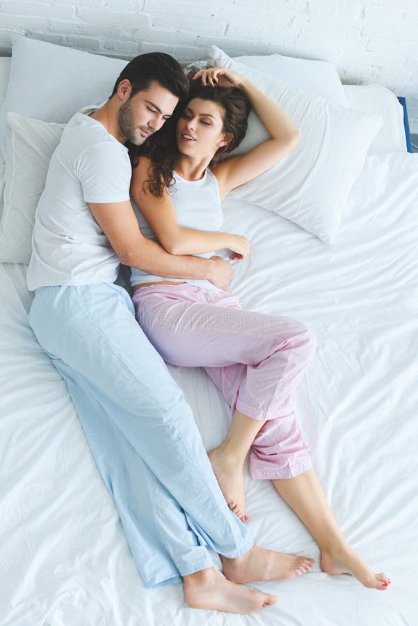 Top View of Beautiful Happy Young Couple in Pajamas Lying Together ... Top View of Beautiful Happy Young Couple in Pajamas Lying Together ...
