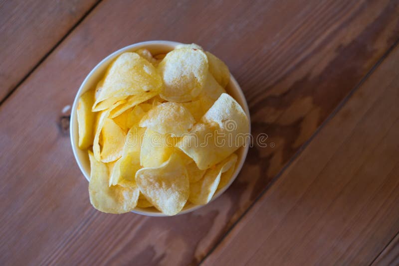 Top View of a Bowl of Potato Chips on a Wooden Table Stock Photo ...