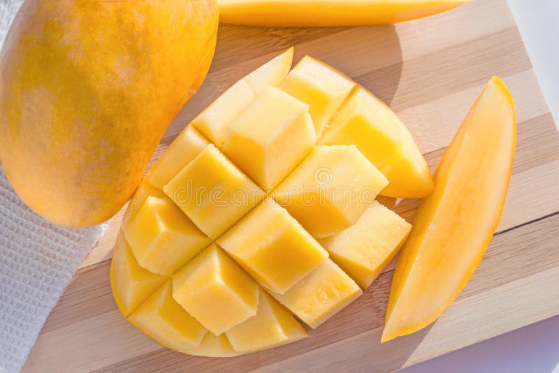 Top View of Bright Yellow Cube Sliced Fresh Mango on Wooden Cutting ... Top View of Bright Yellow Cube Sliced Fresh Mango on Wooden Cutting ...