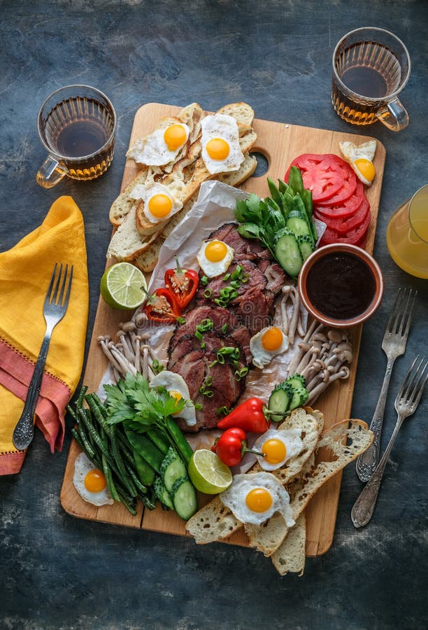 Top View on Buffet Wooden Board with Meat, Eggs, Vegetables, Bread Etc ...