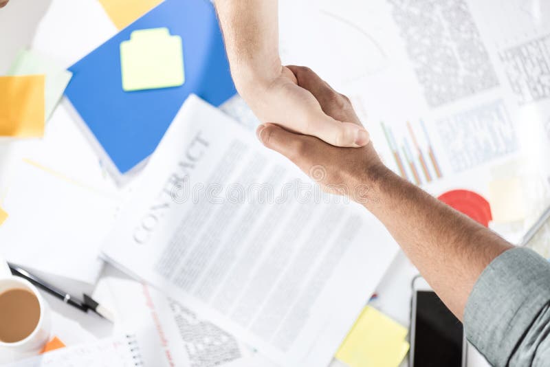 Top View of Businessmen Shaking Hands Above Table with Papers Stock ...