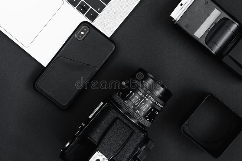 Top View of a Camera and Flash with a Phone on a Laptop on a Dark ...