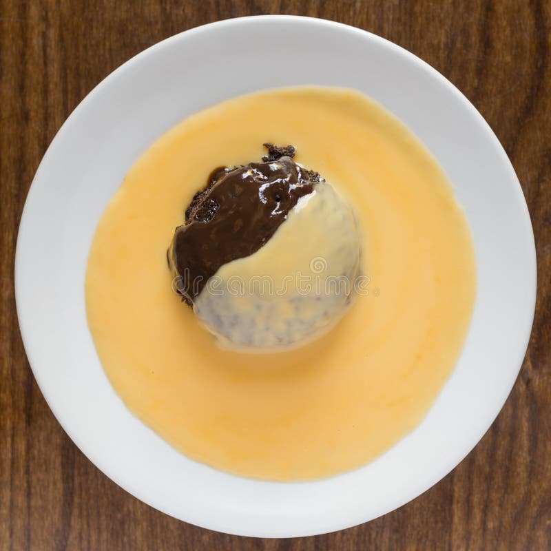 Top View of Chocolate Sponge Pudding with Custard on a Wooden Table ...