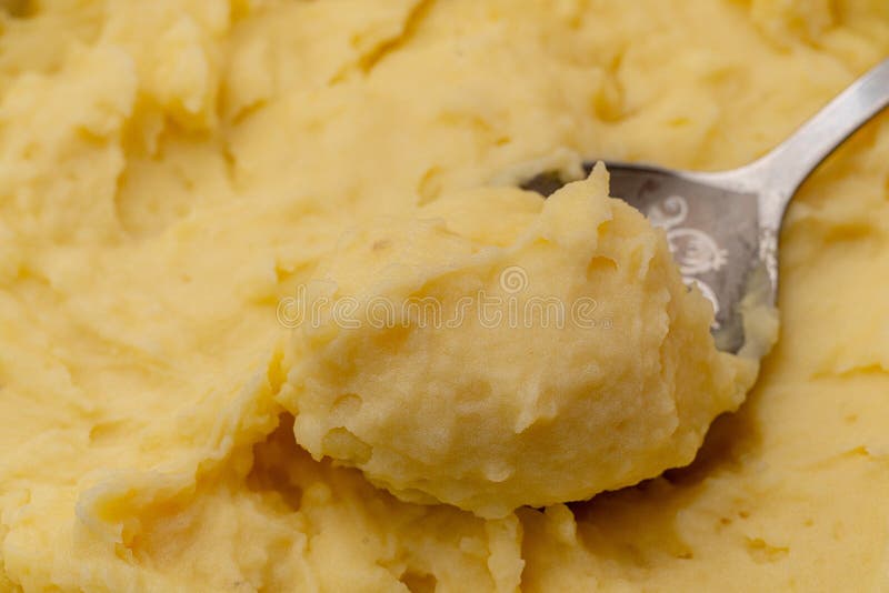 A Top View Close Up of Mashed Yellow Potatoes Texture with Spoon in it ...