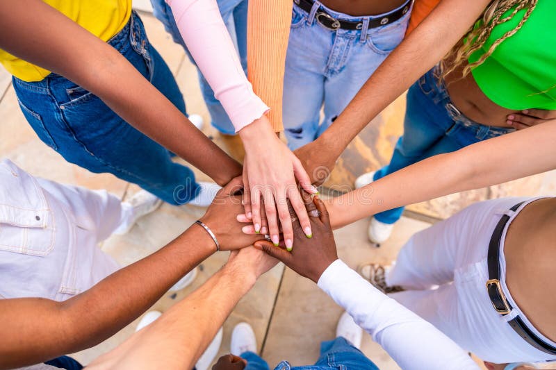 Multi-ethnic Young People Joining Hands in a Huddle Stock Image - Image ...
