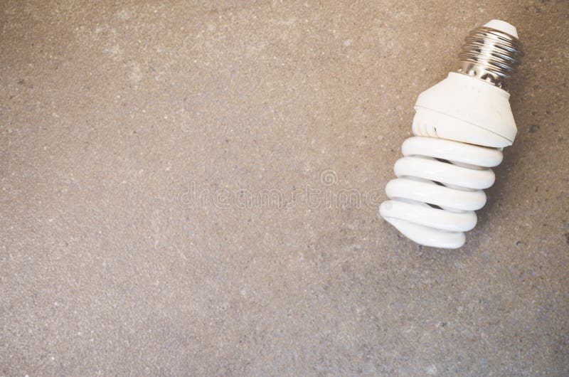 Top View Closeup of a White Spiral Light Bulb on a Toned Rough Stone ...