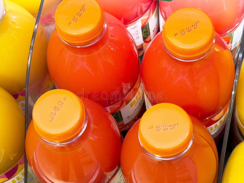 Top View of Colorful Bottles of Fruit Juice with Orange Caps in a Store ...