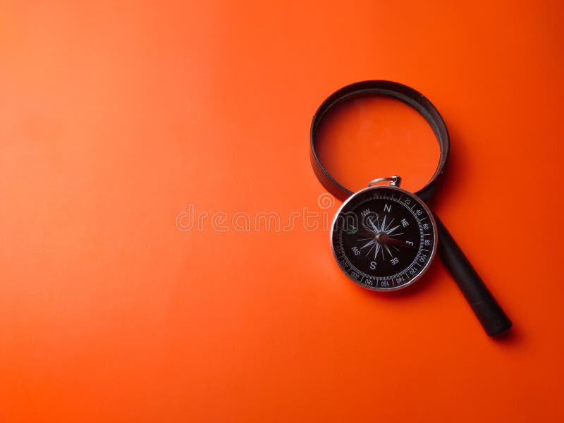 Top View Compass and Magnifying Glass on a Orange Background Stock ...