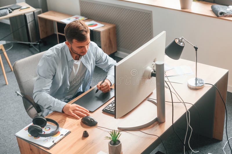 Top View. Designer is Sitting by the Computer and Using Graphics Tablet ...