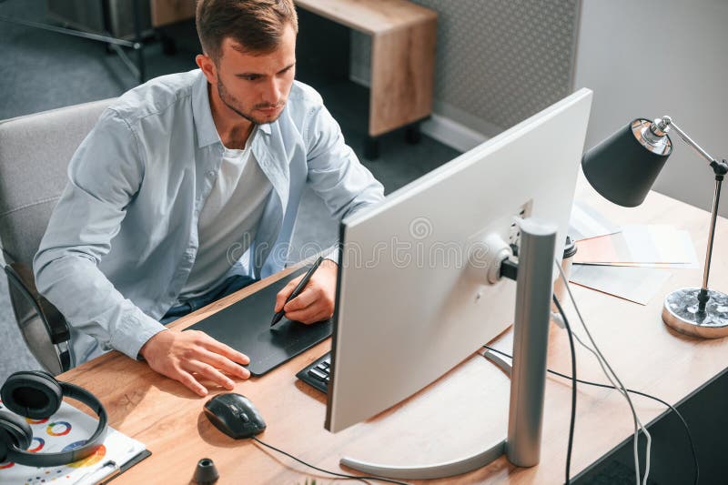 Top View. Designer is Sitting by the Computer and Using Graphics Tablet ...