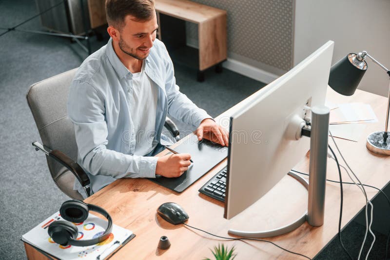 Top View. Designer is Sitting by the Computer and Using Graphics Tablet ...