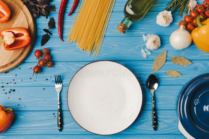Top View of Empty Plate and Ingredients on Blue Table Stock Photo ...