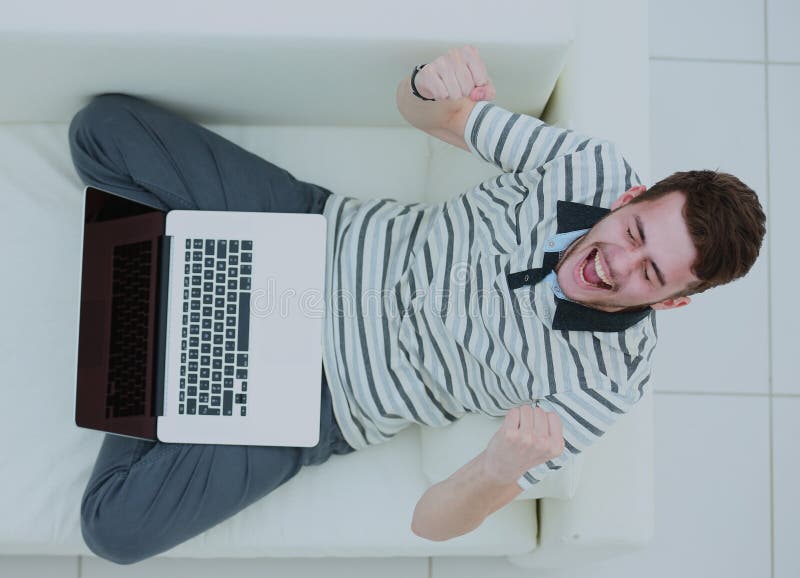 Top View of Excited Young Man Using His Laptop in Bright Living Stock ... Top View of Excited Young Man Using His Laptop in Bright Living Stock ...