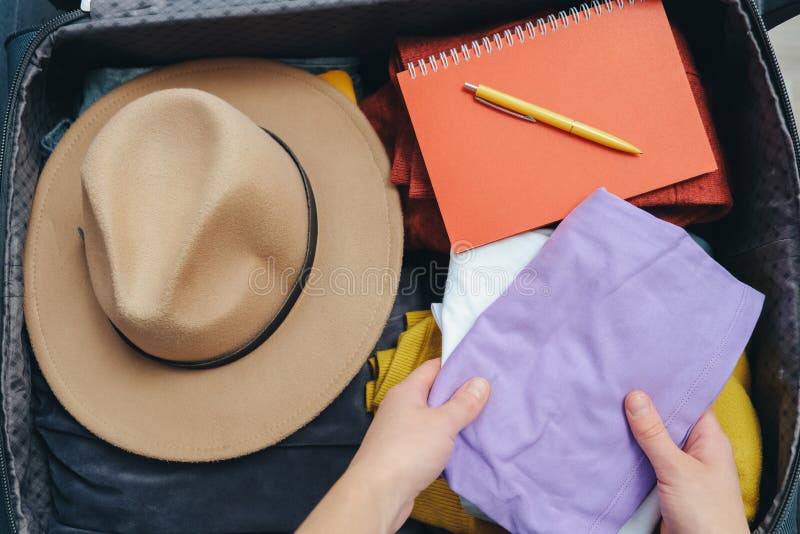 Top View of Female Hands Neatly Packing and Organizing Suitcase. Stack ...
