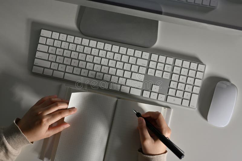 Top View of a Female Working at Her Computer Desk, Writing Something on ...