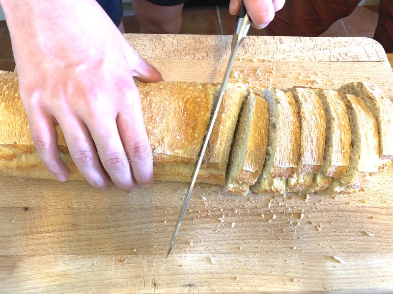 Cutting a loaf of bread stock photo. Image of kitchen - 155703764