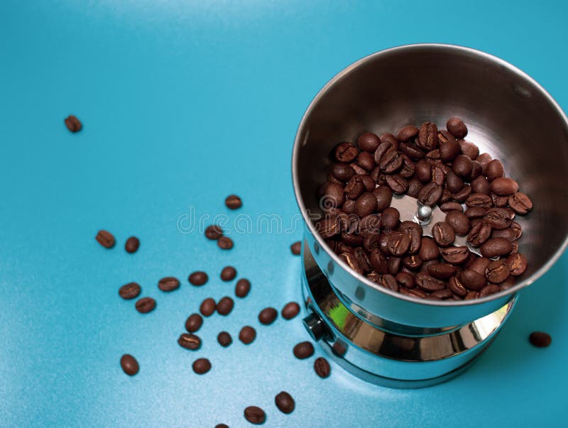 Grinding Coffee Beans in an Electric Coffee Grinder on a Blue ...