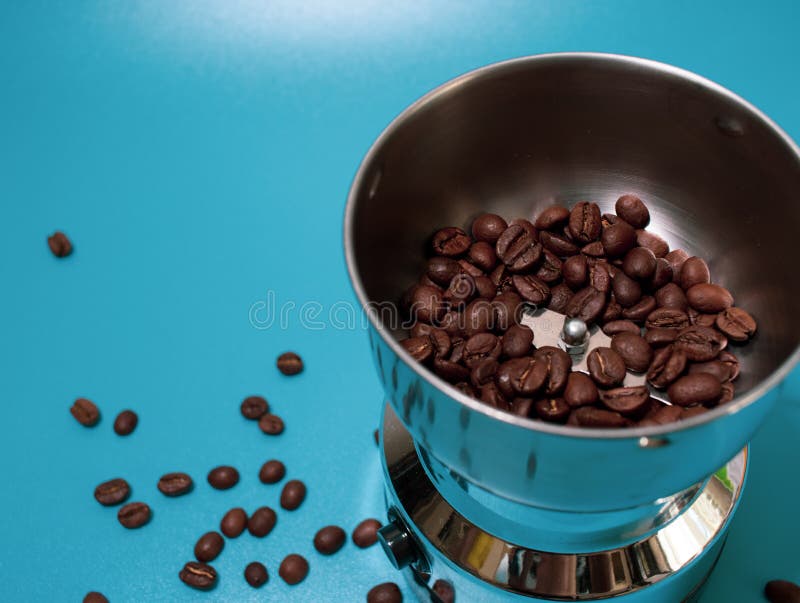 Grinding Coffee Beans in an Electric Coffee Grinder on a Blue ...