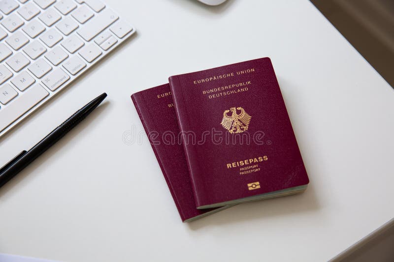 Top View of a German Passport on White Table, with a Pan, a Computer ...