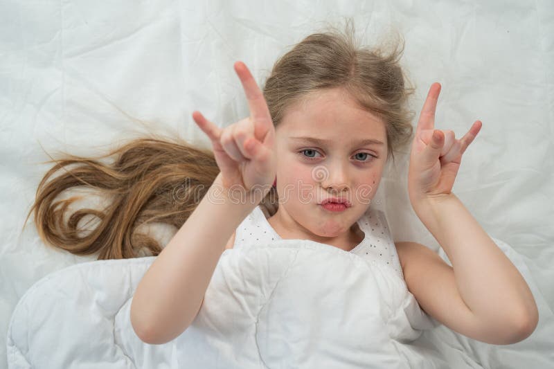 Top View of a Grimacing Little Girl Lying in Bed. Stock Image - Image ...