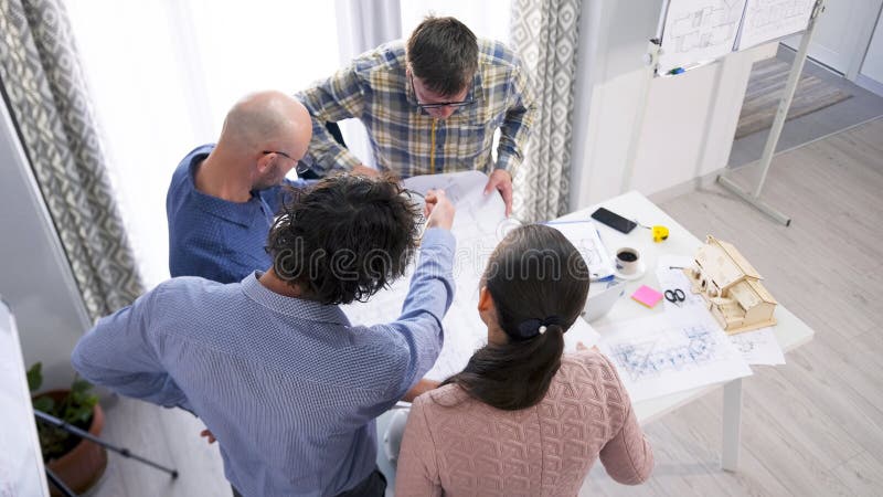 Top View of a Group of Architects Working on Building Drawings. a Group ...