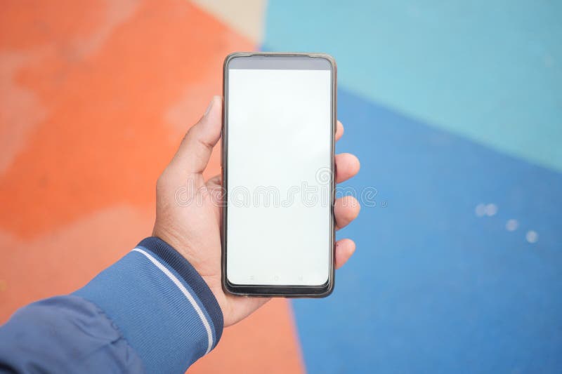 Top View of Hand Holding a Smart Phone with Empty Screen on Color ...