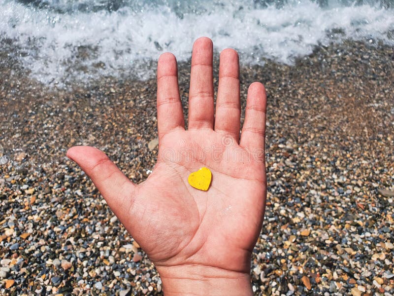 Top View of a Hand Holding a Yellow Heart Shape at Beach Stock Image ...