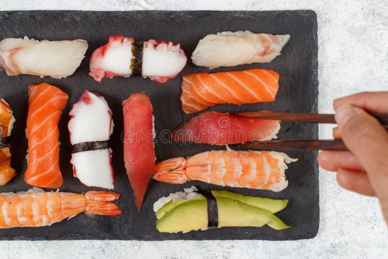 Top View of Hand Taking Roll with Chopsticks from a Plate Stock Photo ...
