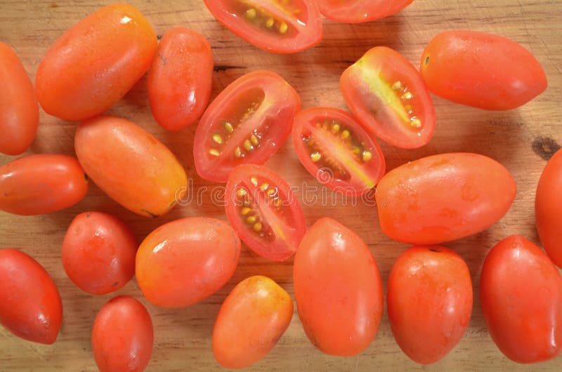 Small Red Tomatoes with Calyxes on Black Floor Stock Photo - Image of ...