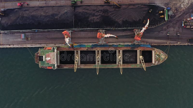 Top View of Loading a Cargo Ship with Coal Using Port Cranes. Drone ...
