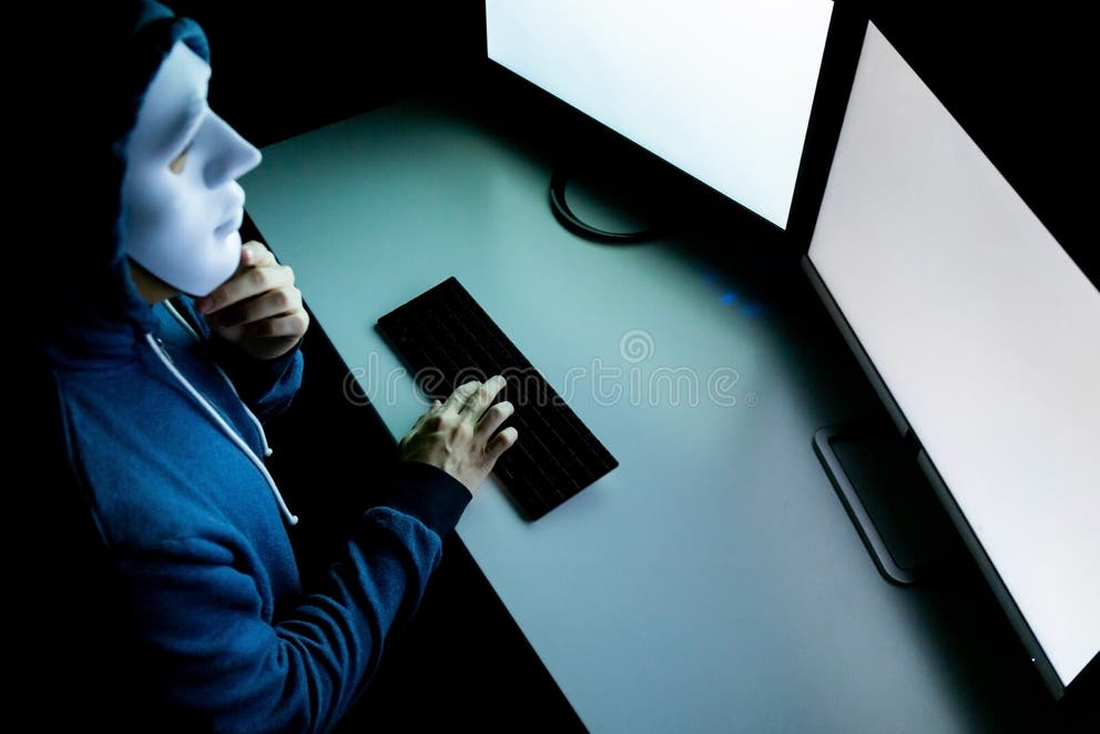 Top View of Male Hacker in Mask Under Hood Using Computer To Hack into ...
