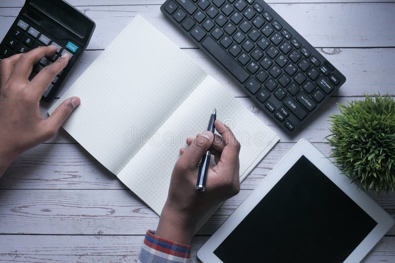 Top View of Man Hand Writing on Notepad and Using Calculator Stock ...
