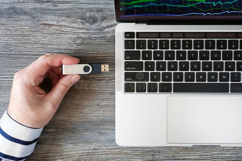 Top View of a Man Inserting a Flash Drive into a Laptop on a Wooden ...