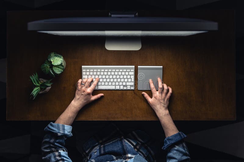 Top View of a Man Working at a Computer in a Dark Room at Night. Stock ...