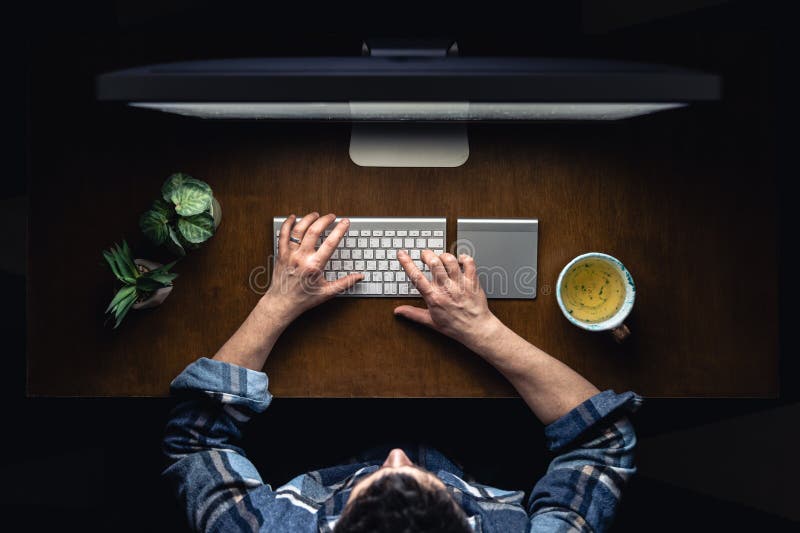 Top View of a Man Working at a Computer in a Dark Room at Night. Stock ...