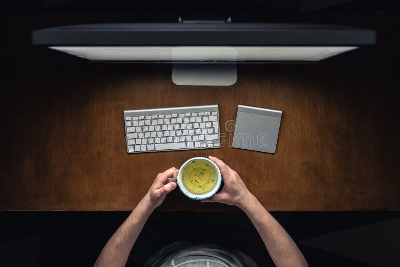 Top View of Man Working on Computer at Night, Holding Mug of Tea. Stock ...